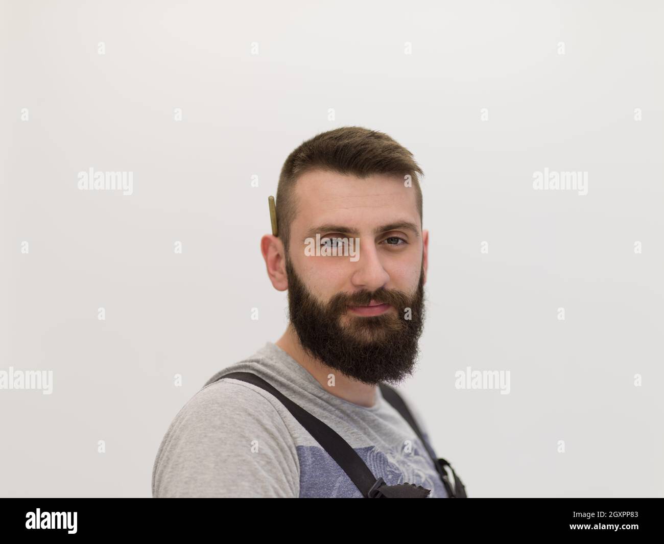 portrait of bearded hipster handyman with pen behind ear isolated on ...