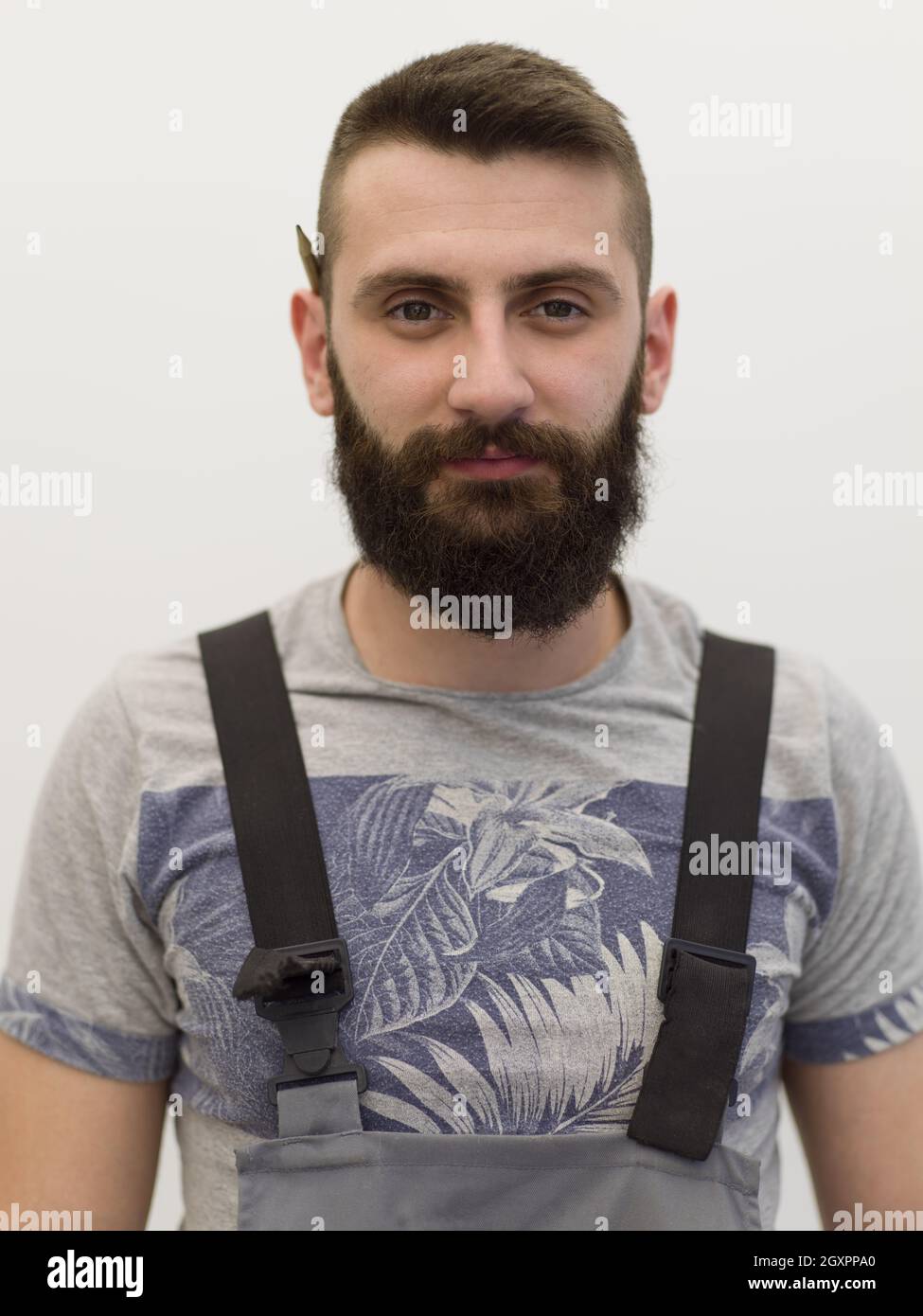 portrait of bearded hipster handyman with pen behind ear isolated on ...