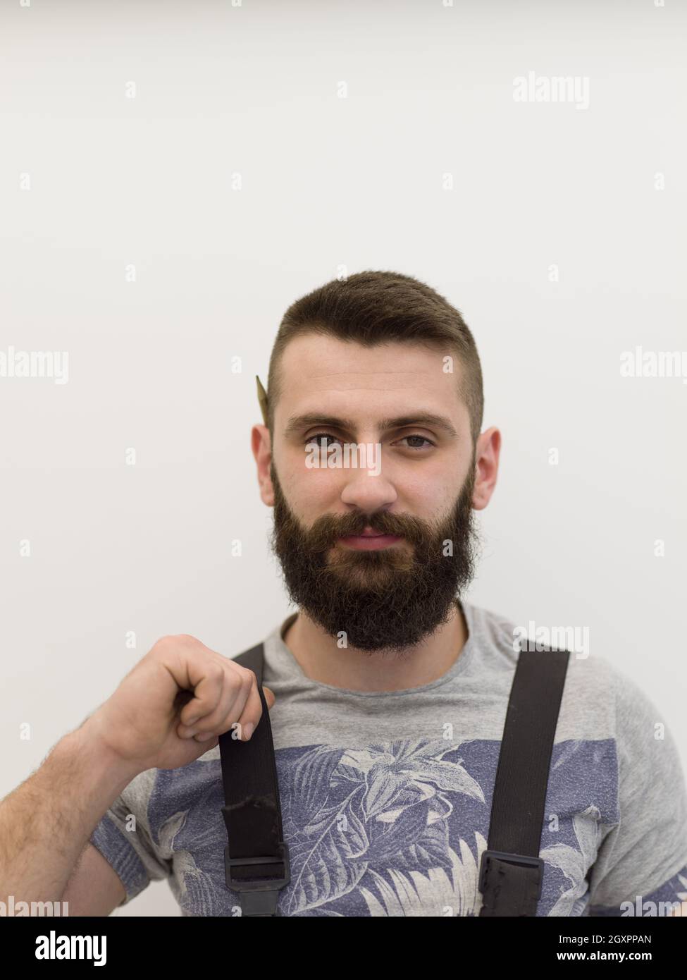 portrait of bearded hipster handyman with pen behind ear isolated on ...