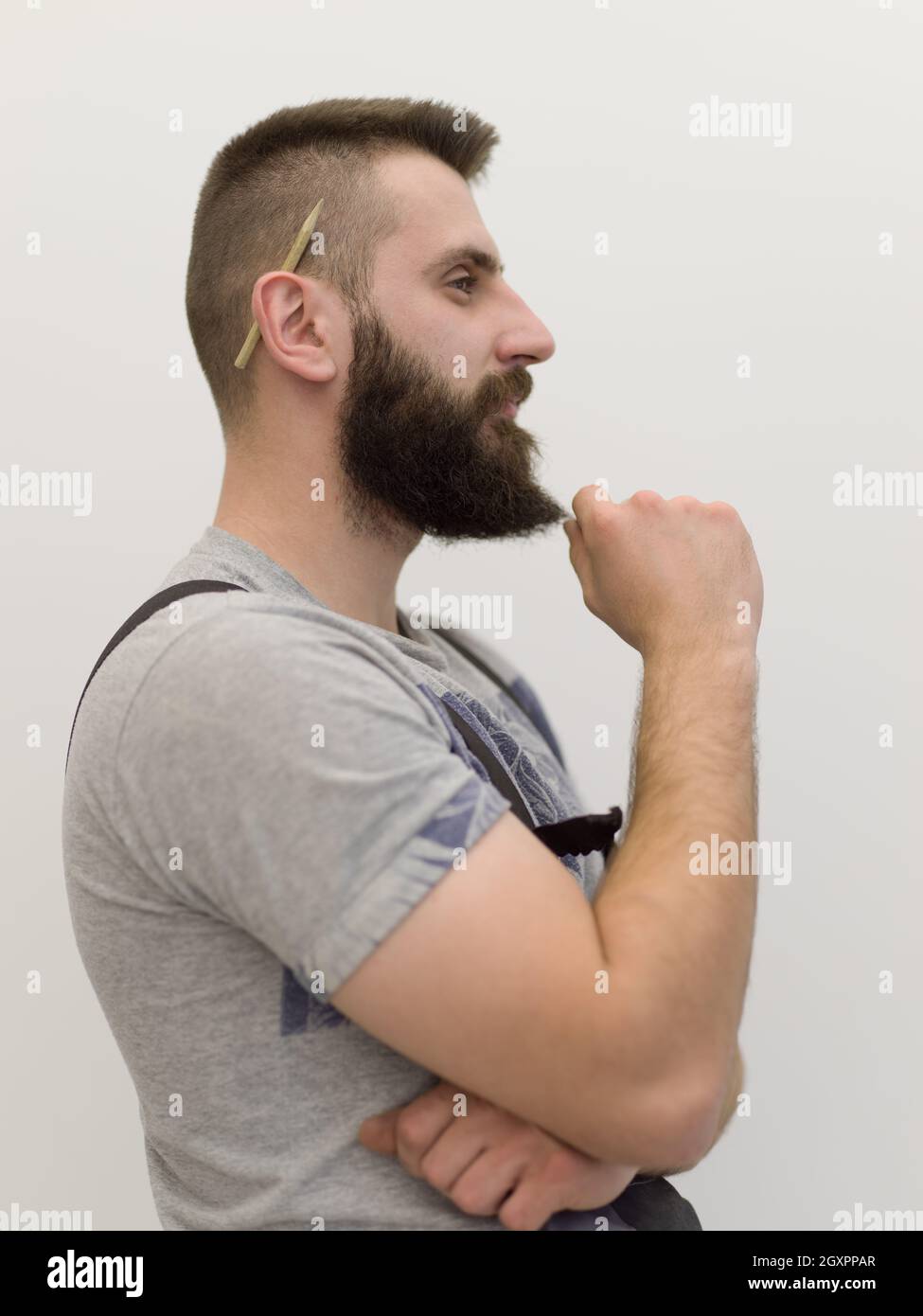 portrait of bearded hipster handyman with pen behind ear isolated on ...