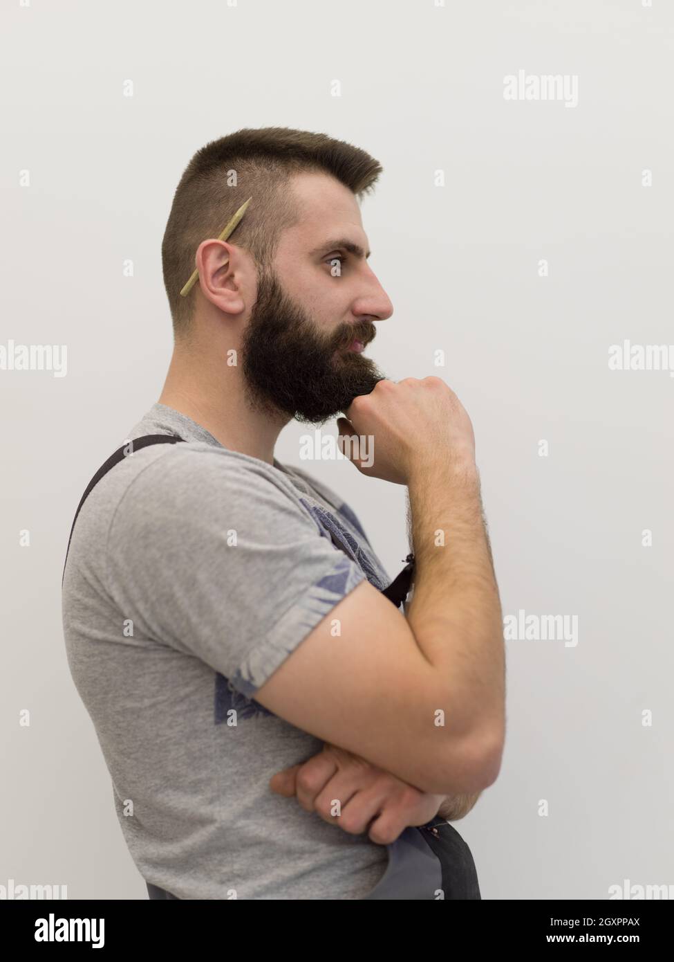 portrait of bearded hipster handyman with pen behind ear isolated on ...