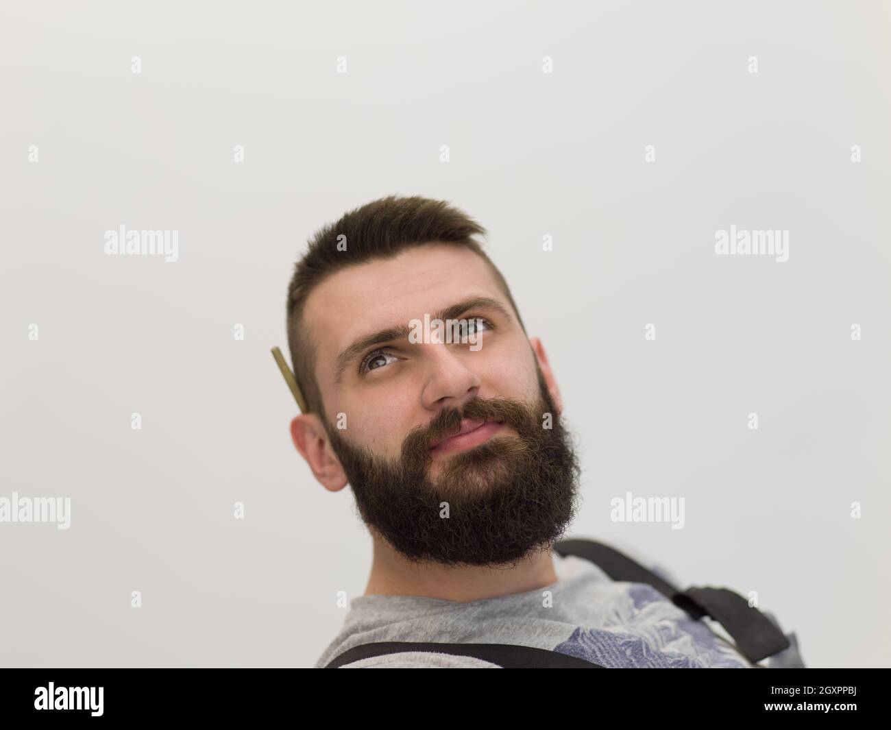 portrait of bearded hipster handyman with pen behind ear isolated on ...