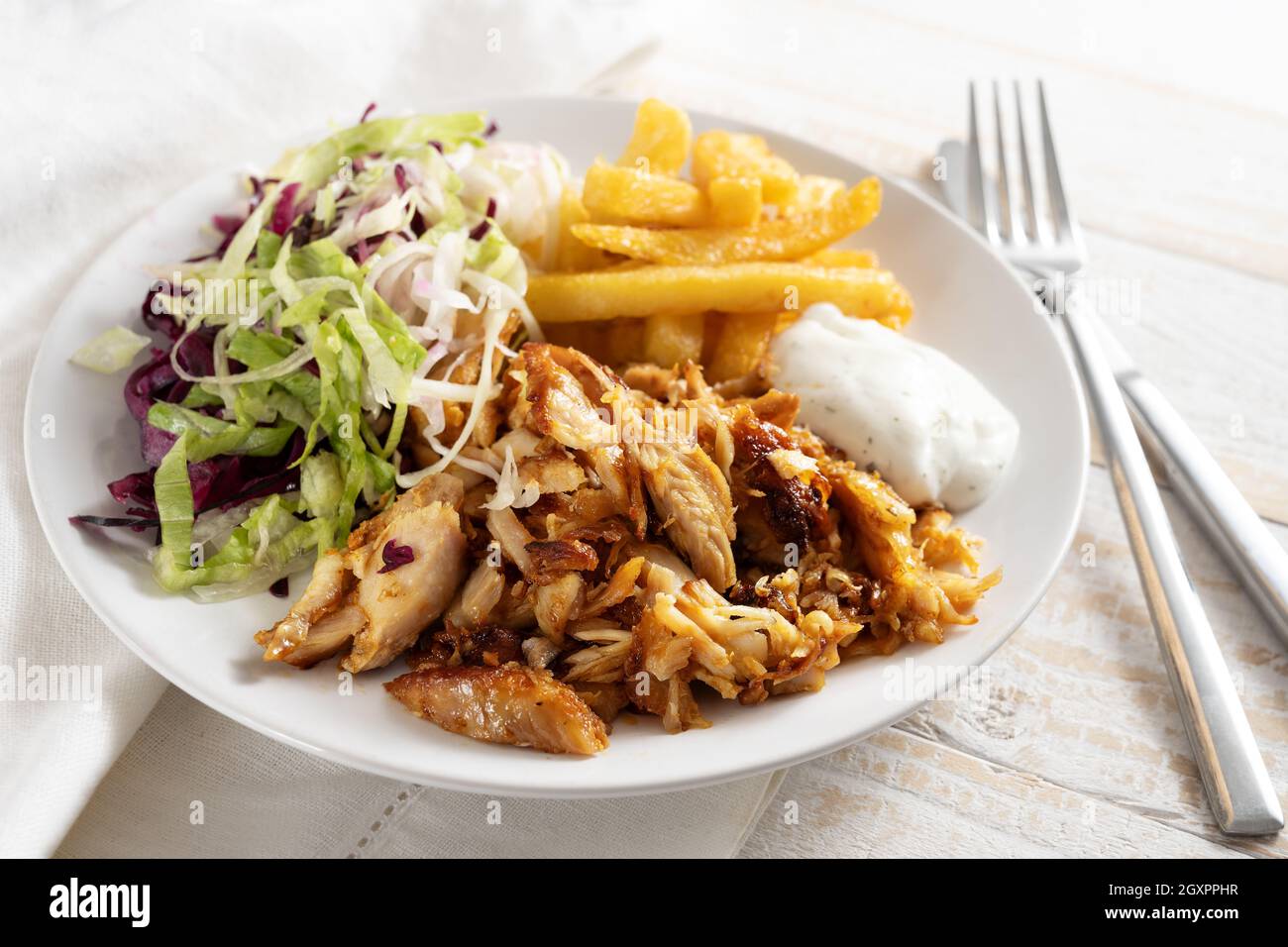 Doner kebab chicken meat with french fries, salad and tzatziki dip on a ...
