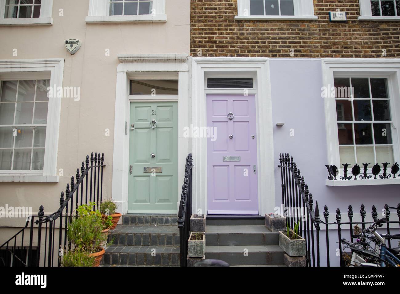 Colorful British houses with plants and handrails outside. Beautiful ...