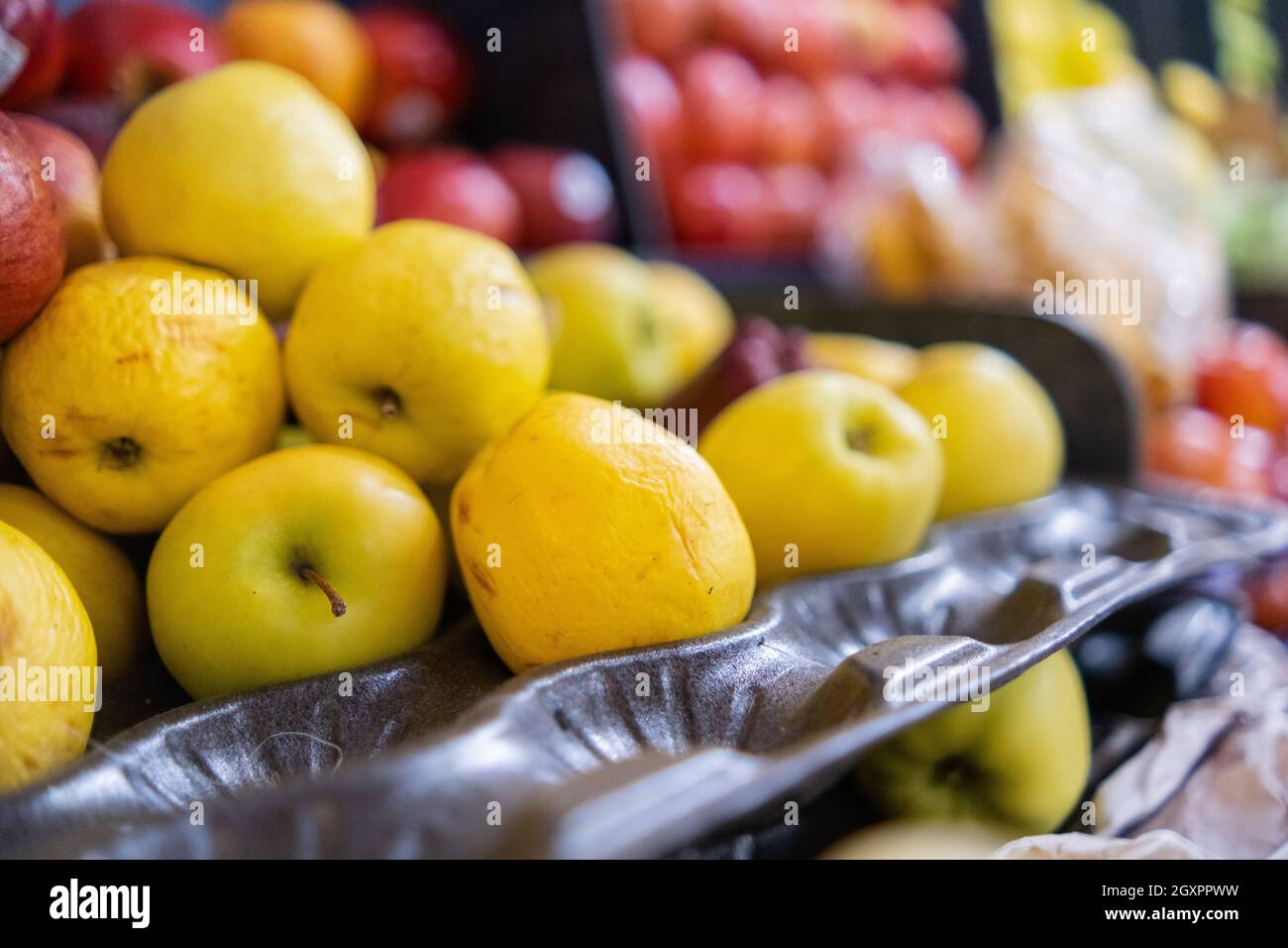 Close-up of colorful fruit stand with fresh yellow and red apples, and ...