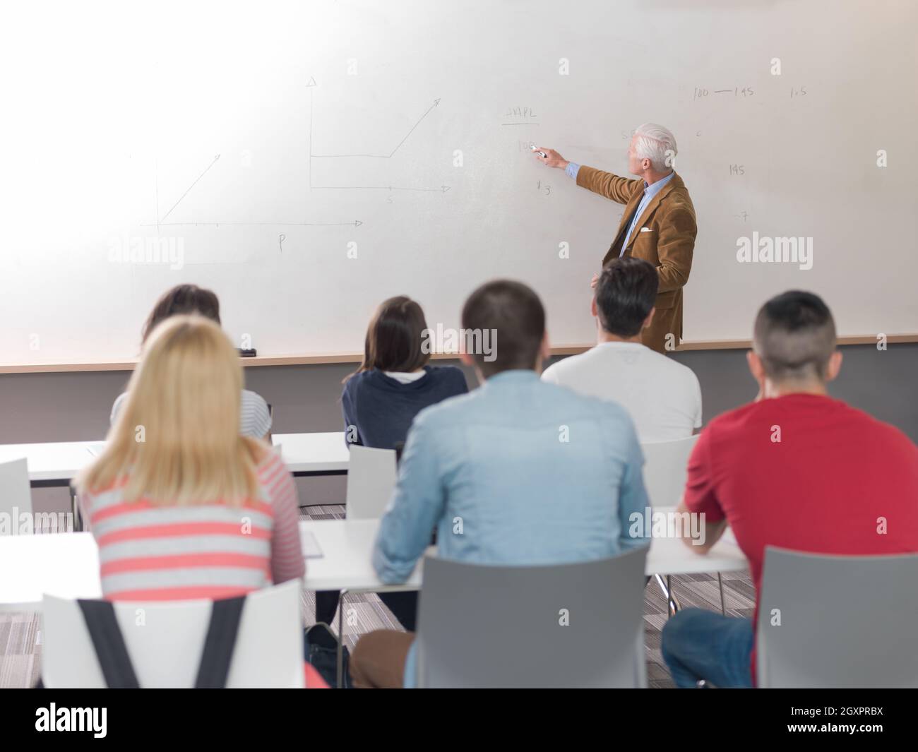 senior teacher with group of happy students in modern school classroom ...