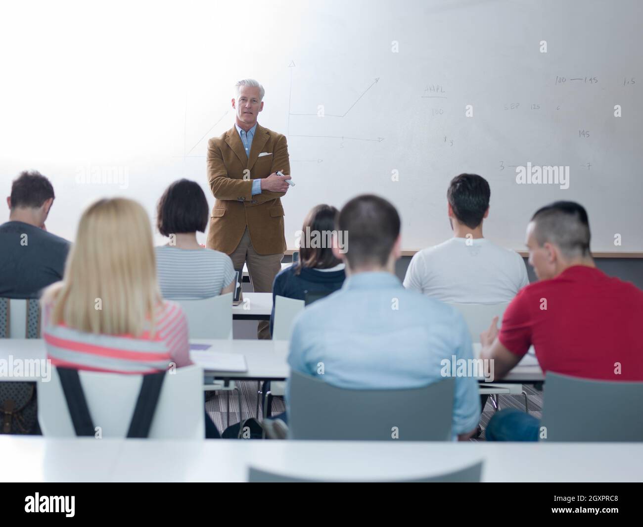 senior teacher with group of happy students in modern school classroom ...