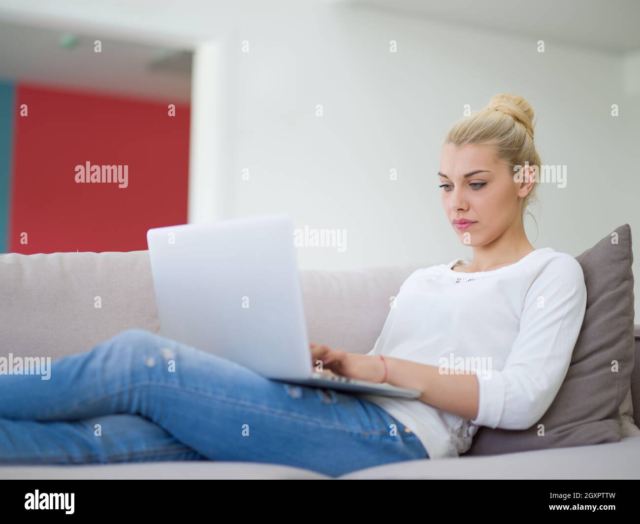 Young woman using her laptop computer in her luxury modern home ...