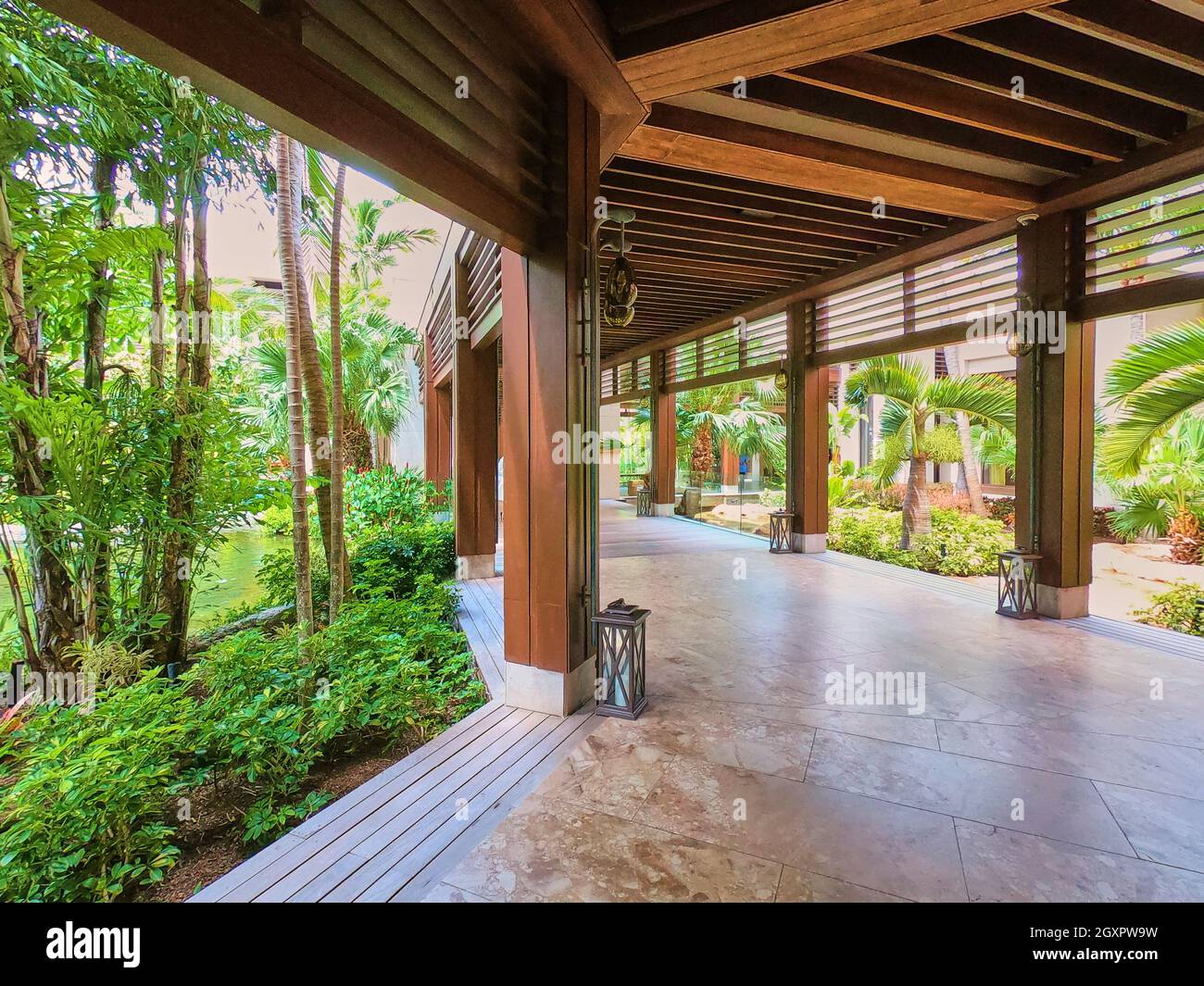 Covered tropical walkway surrounded by gardens Stock Photo - Alamy