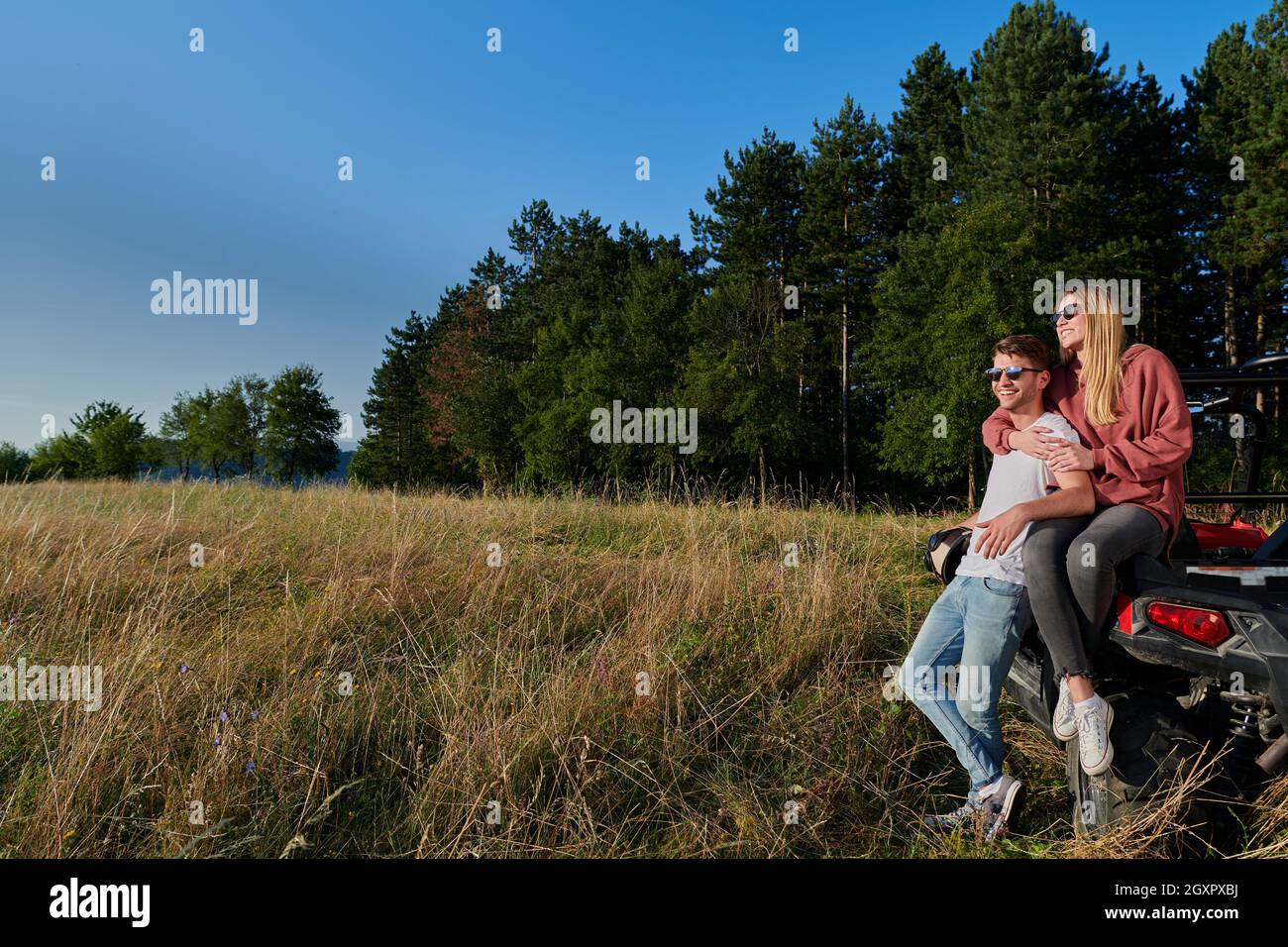 portrait of young happy excited couple enjoying beautiful sunny day while driving a off road ...