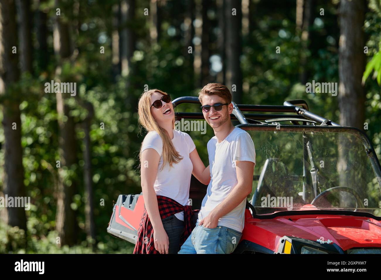 portrait of young happy excited couple enjoying beautiful sunny day while driving a off road ...