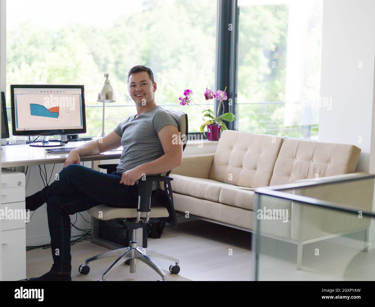 portrait of security system operator looking at CCTV footage at desk in ...