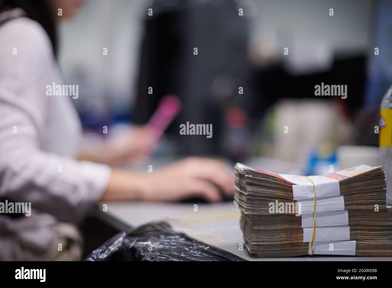 Bank employees using money counting machine while sorting and counting ...