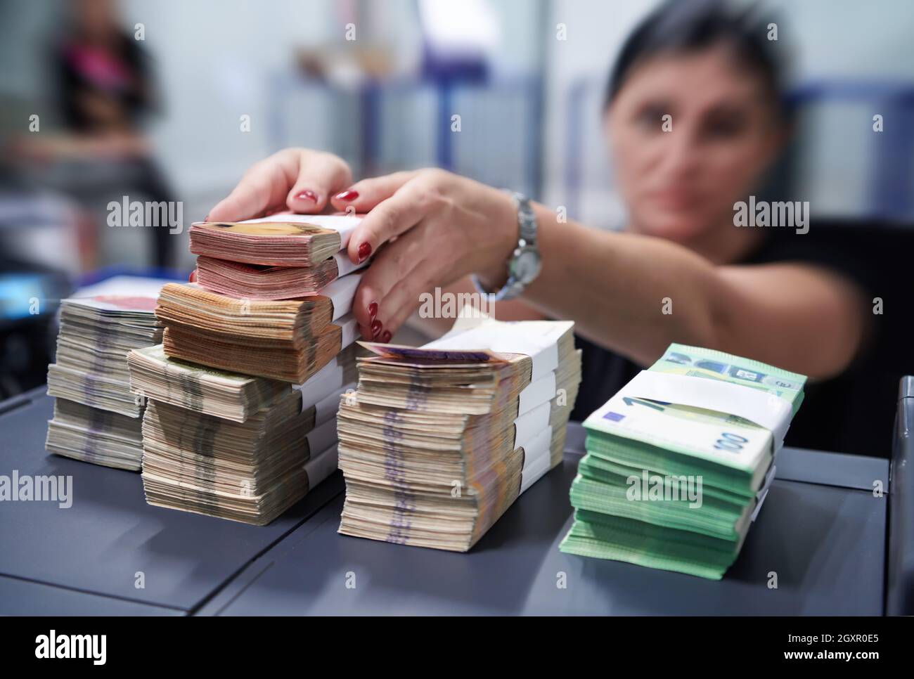 Bank employees using money counting machine while sorting and counting ...