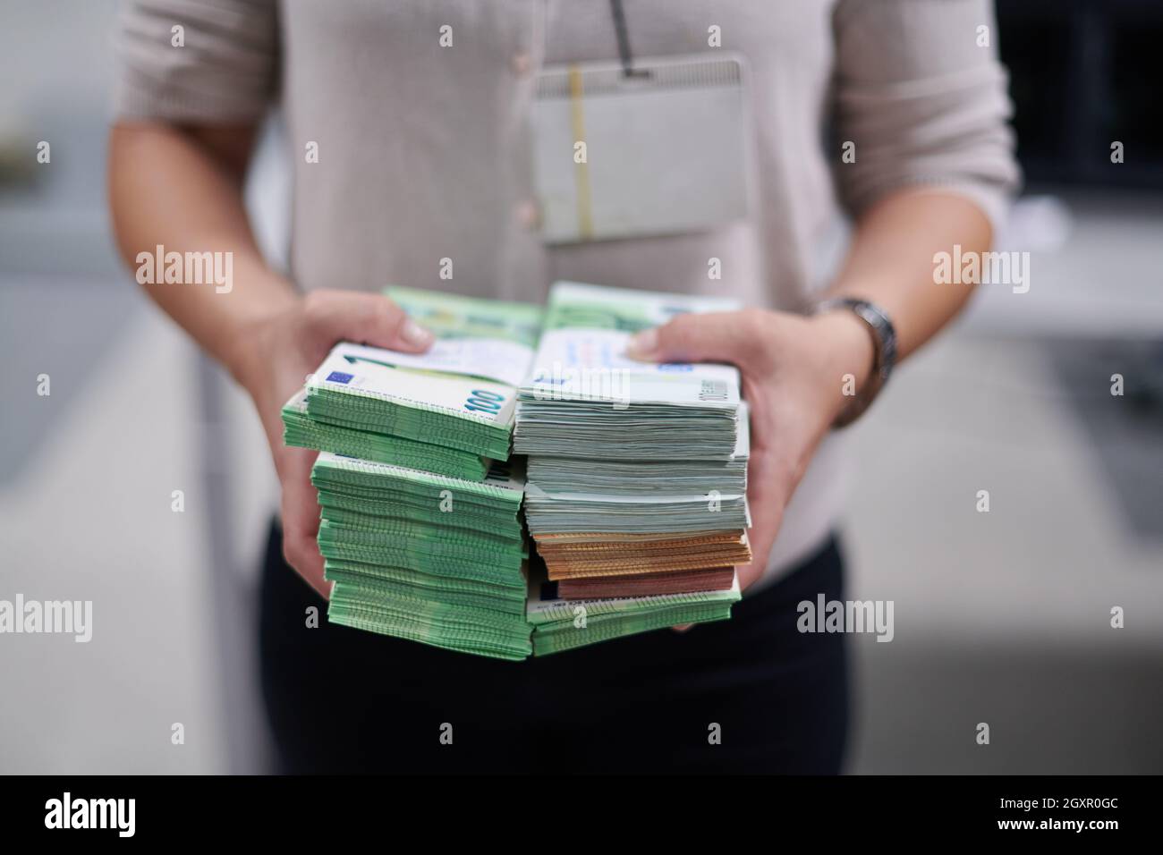 Bank employees holding a pile of paper banknotes while sorting and ...