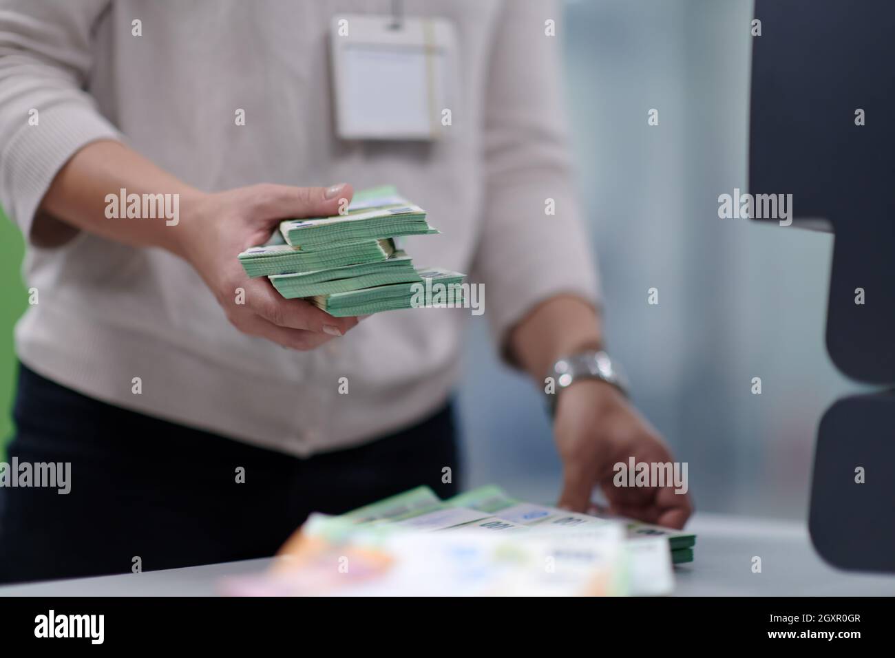 Bank employees using money counting machine while sorting and counting ...