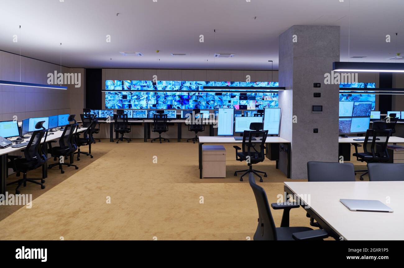Empty interior of big modern security system control room, workstation with multiple displays ...