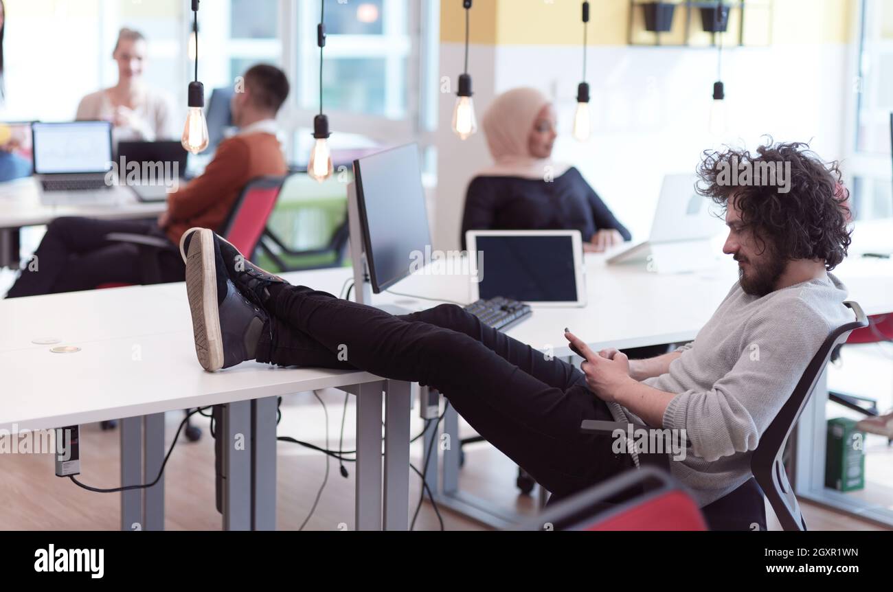 relaxed businessman as startup entrepreneur working on desktop computer ...