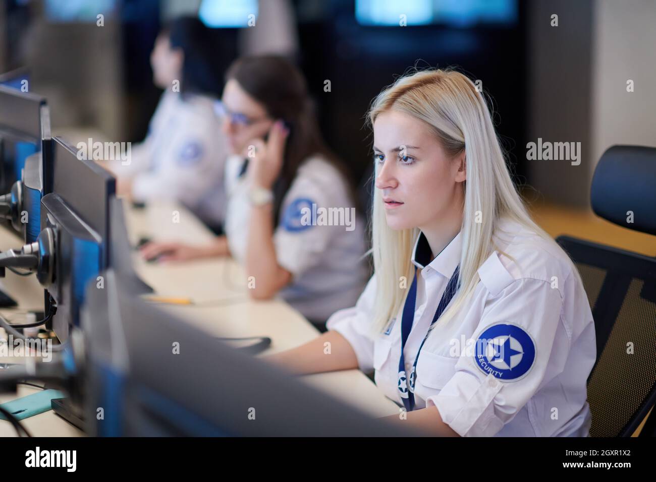 Female security operator working in a data system control room offices ...