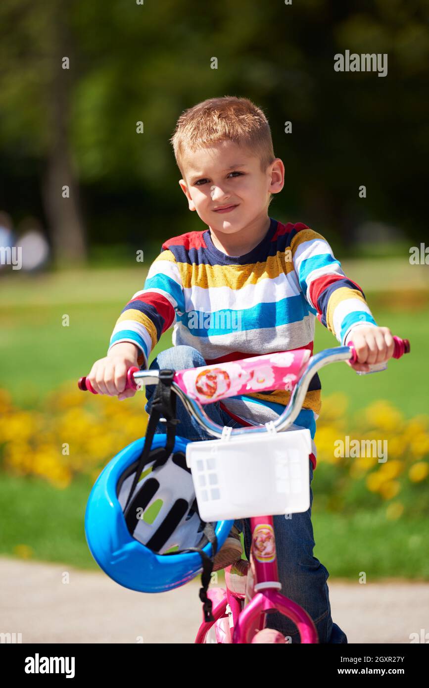 happy little boy have fun in park and learning to ride his first bike ...