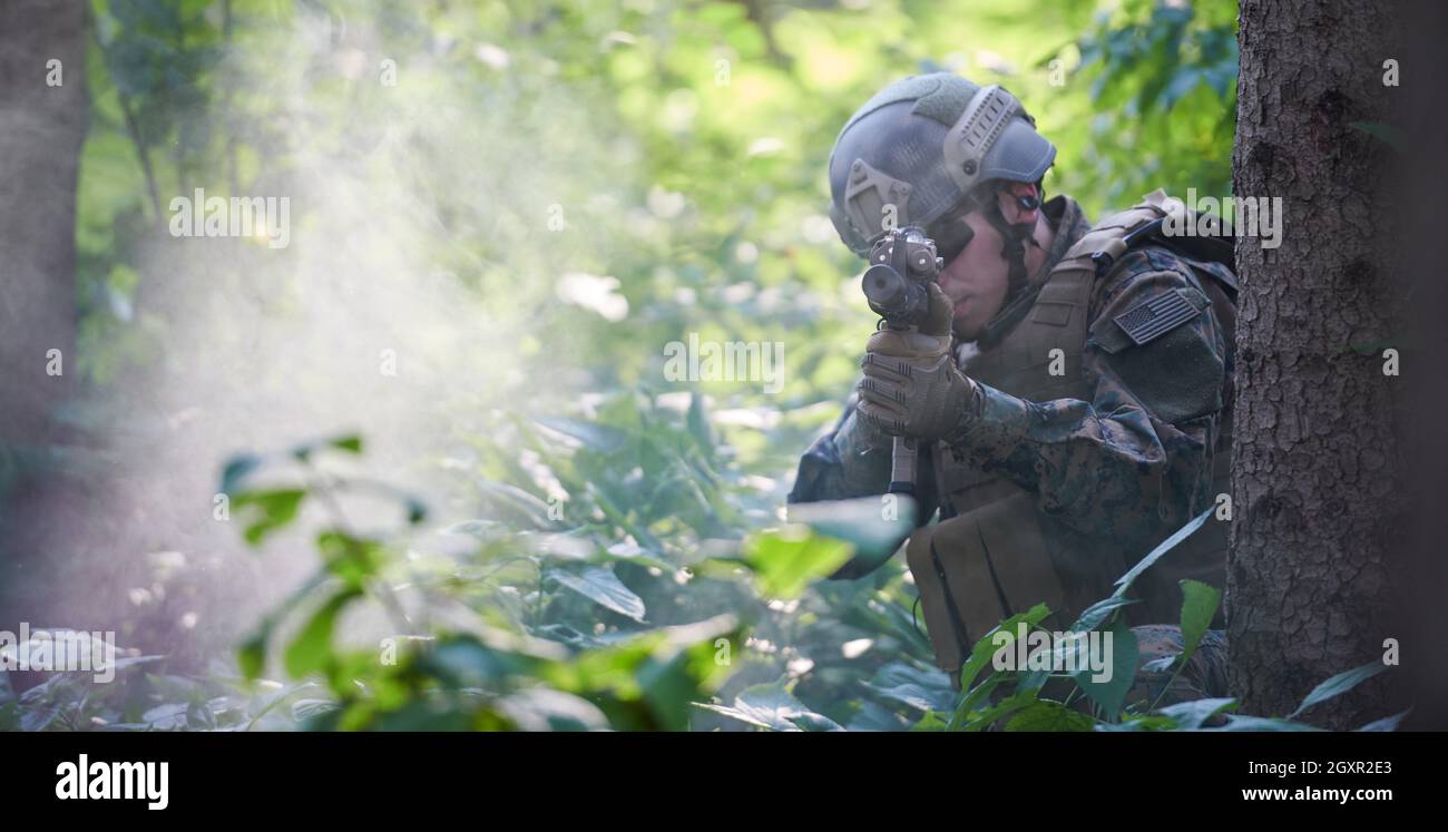 modern warfare soldier in action aiming at weapon laser sight optics in ...