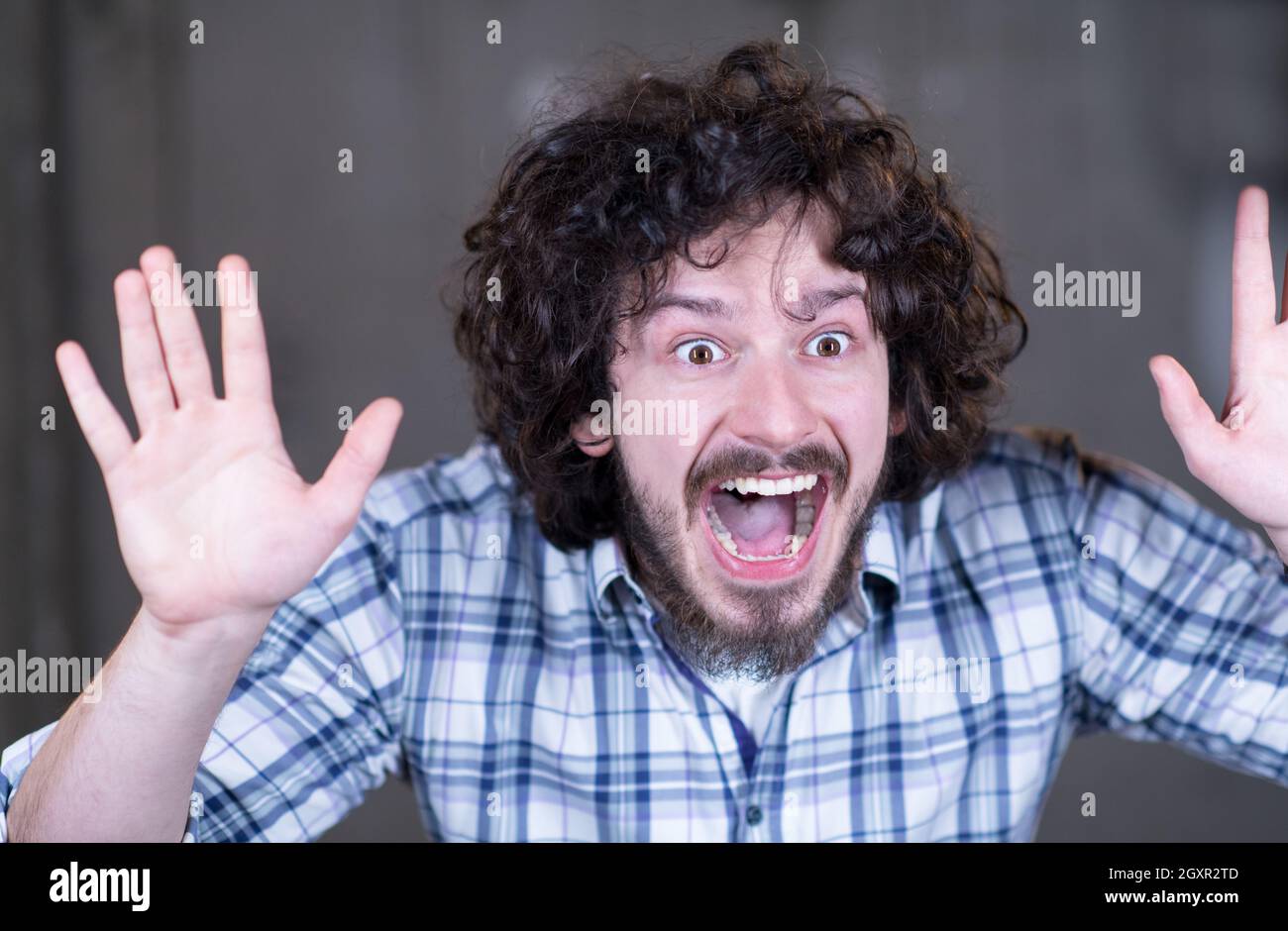 young successful casual businessman screaming in front of a concrete ...