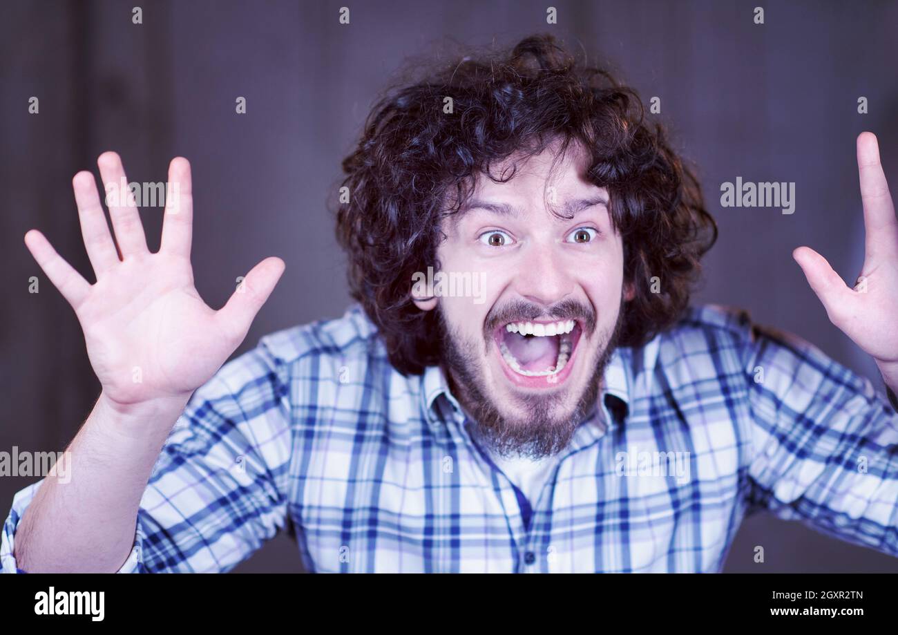 young successful casual businessman screaming in front of a concrete ...