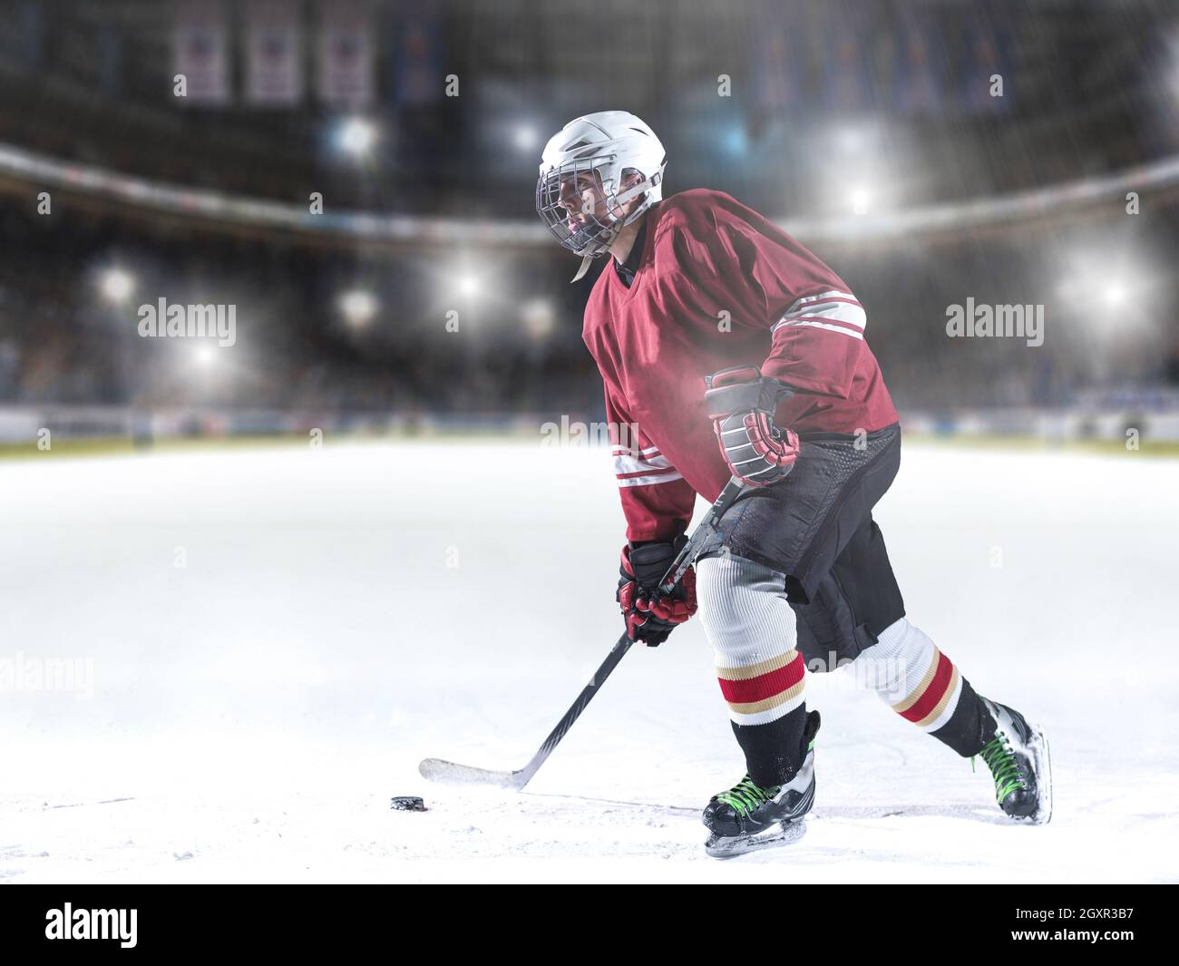 ice hockey player in action kicking with stick in front of big modern ...