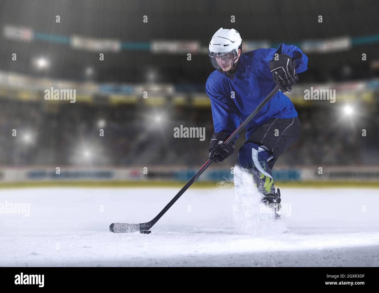ice hockey player in action kicking with stick in front of big modern ...