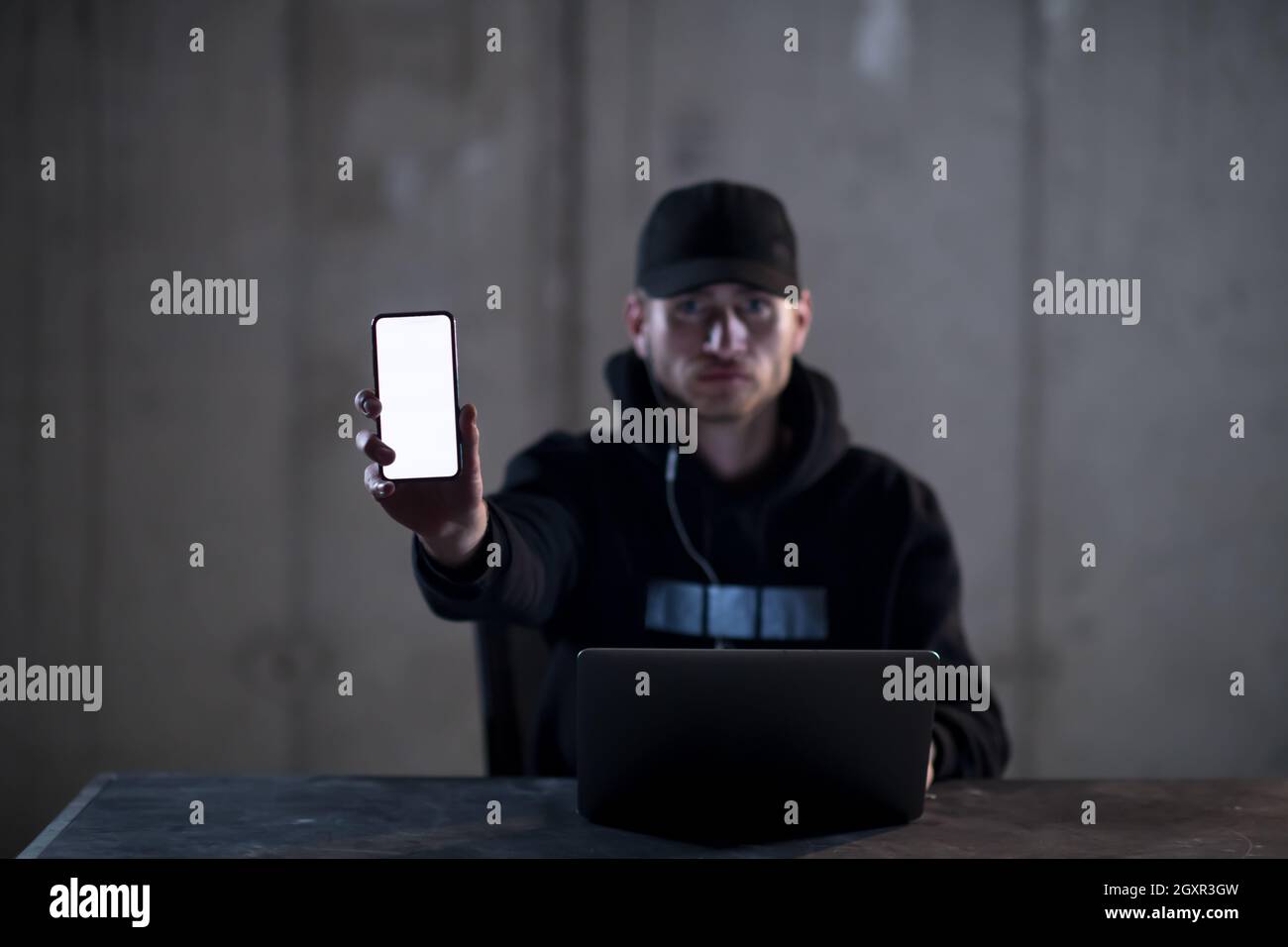 Young talented criminal hacker using laptop computer and showing the ...