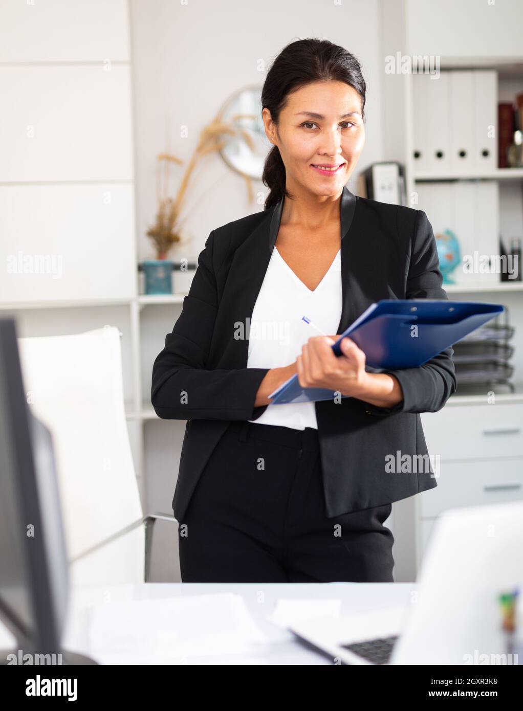 Office worker is standing with documents before signing it in office ...