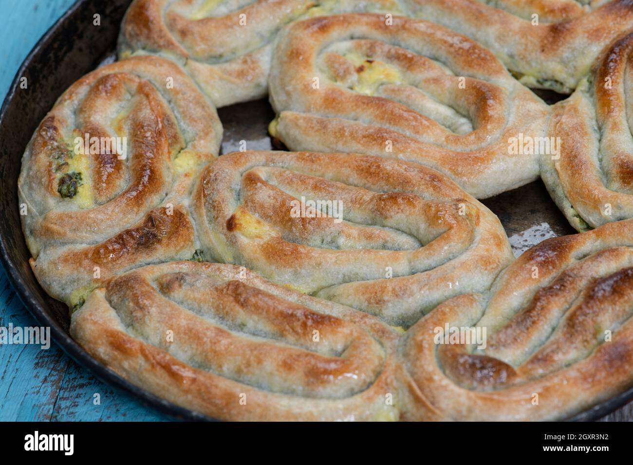 burek pie in a rustic wooden blue setting background and authentic dish ...