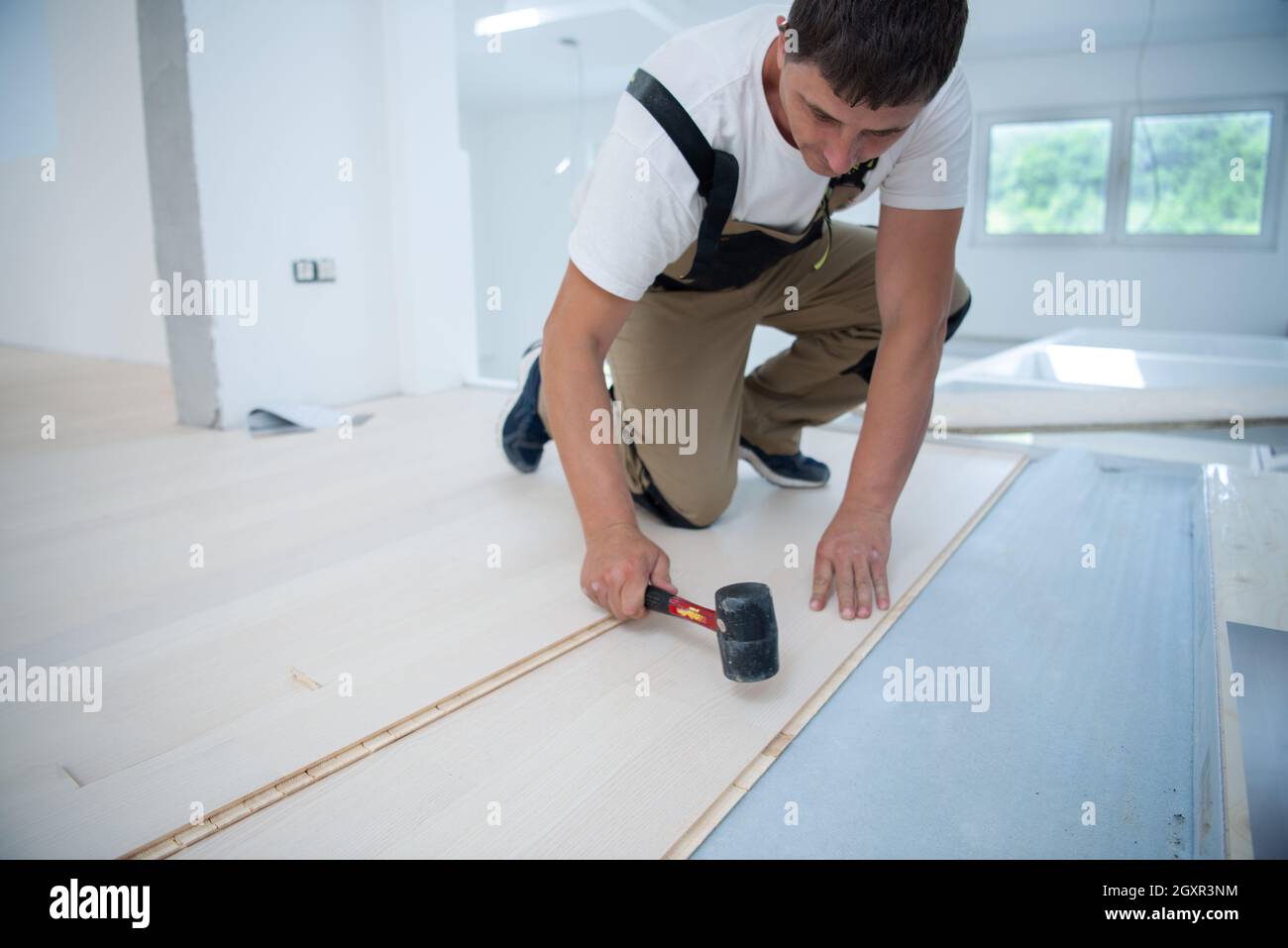 professional carpenter using rubber hammer while installing new ...