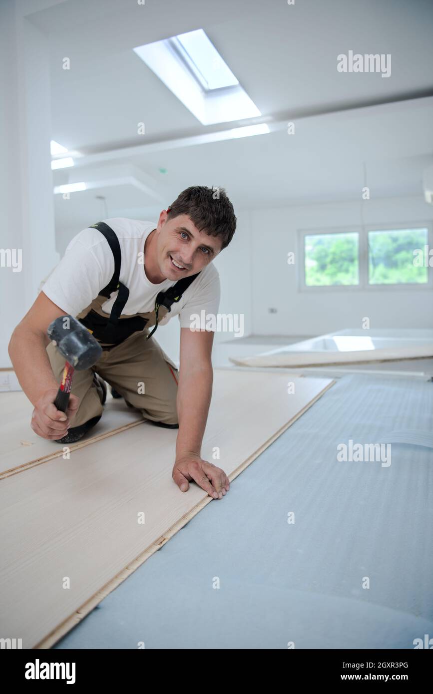 professional carpenter using rubber hammer while installing new ...