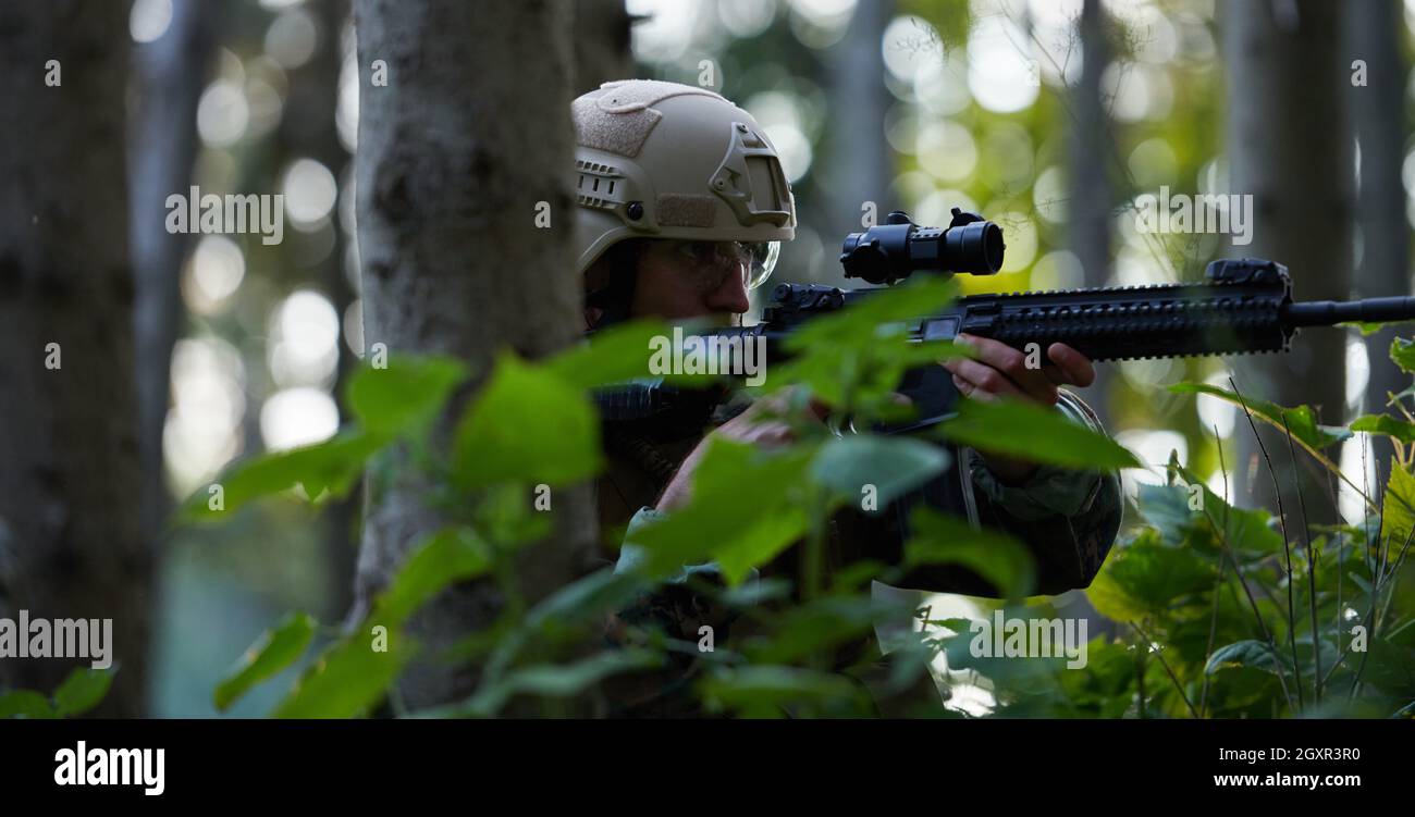 modern warfare soldier in action aiming at weapon laser sight optics in ...