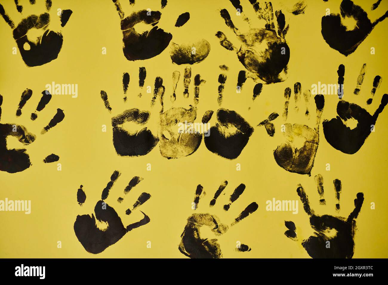 creative children black handprints painting on yellow paper Stock Photo ...