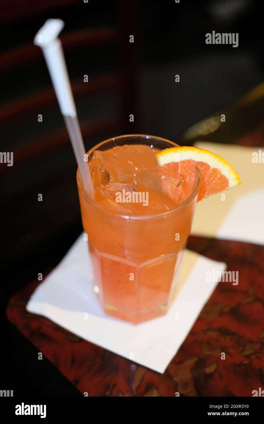 Pink Italian grape fruit flavored soda pop beverage with ice and straw ...