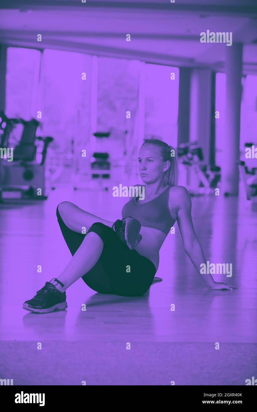 Cute young woman stretching and warming up for her training at a gym ...