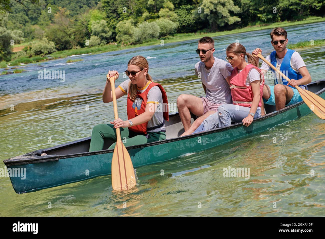 Group adventurous explorer friends are canoeing in a wild river ...