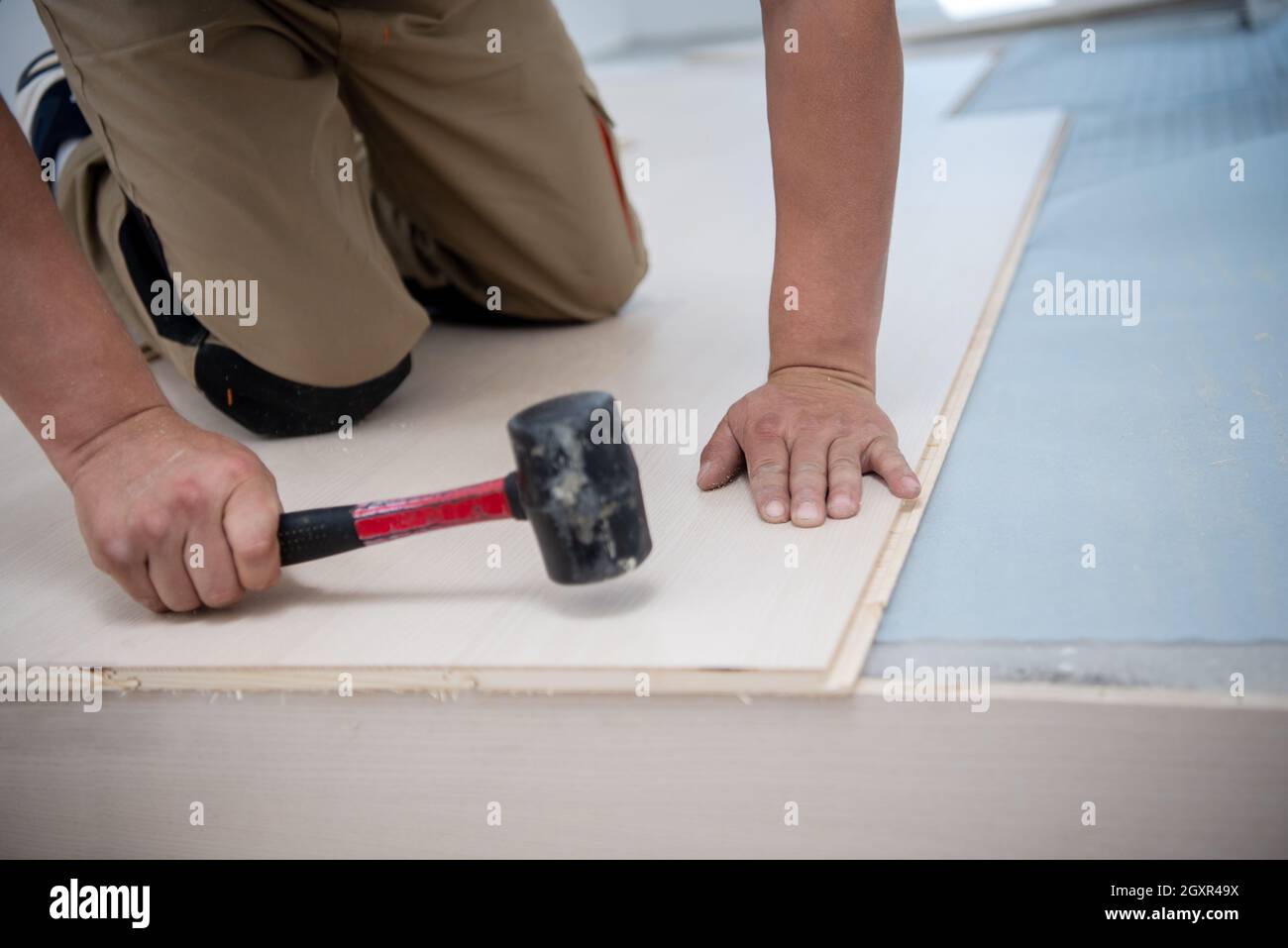professional carpenter using rubber hammer while installing new ...