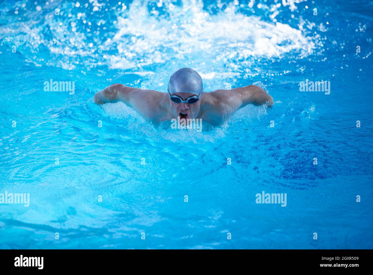 swimmer excercise on indoor swimming pool, sport and health concept ...
