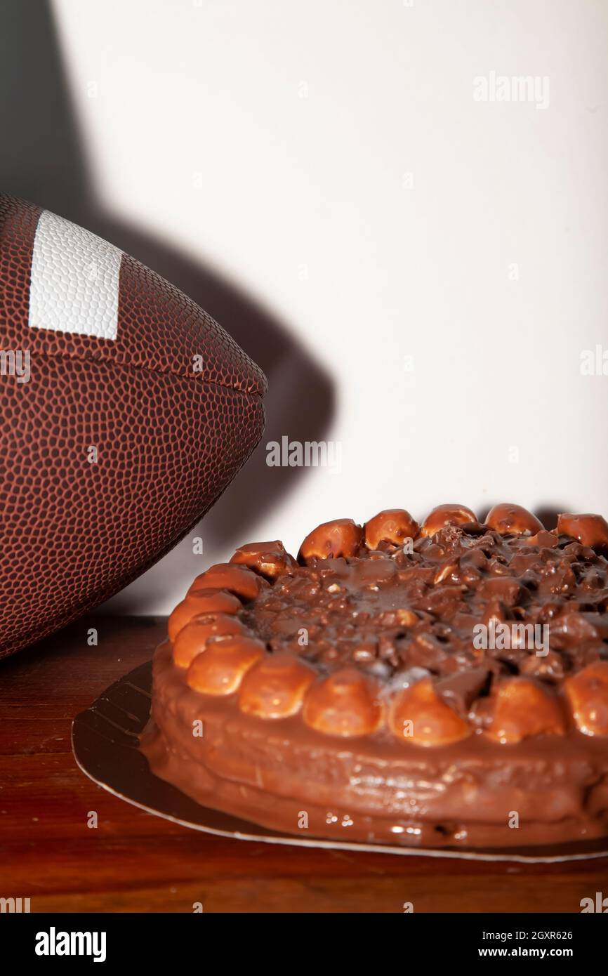Whole chocolate cake next to a game football Stock Photo - Alamy