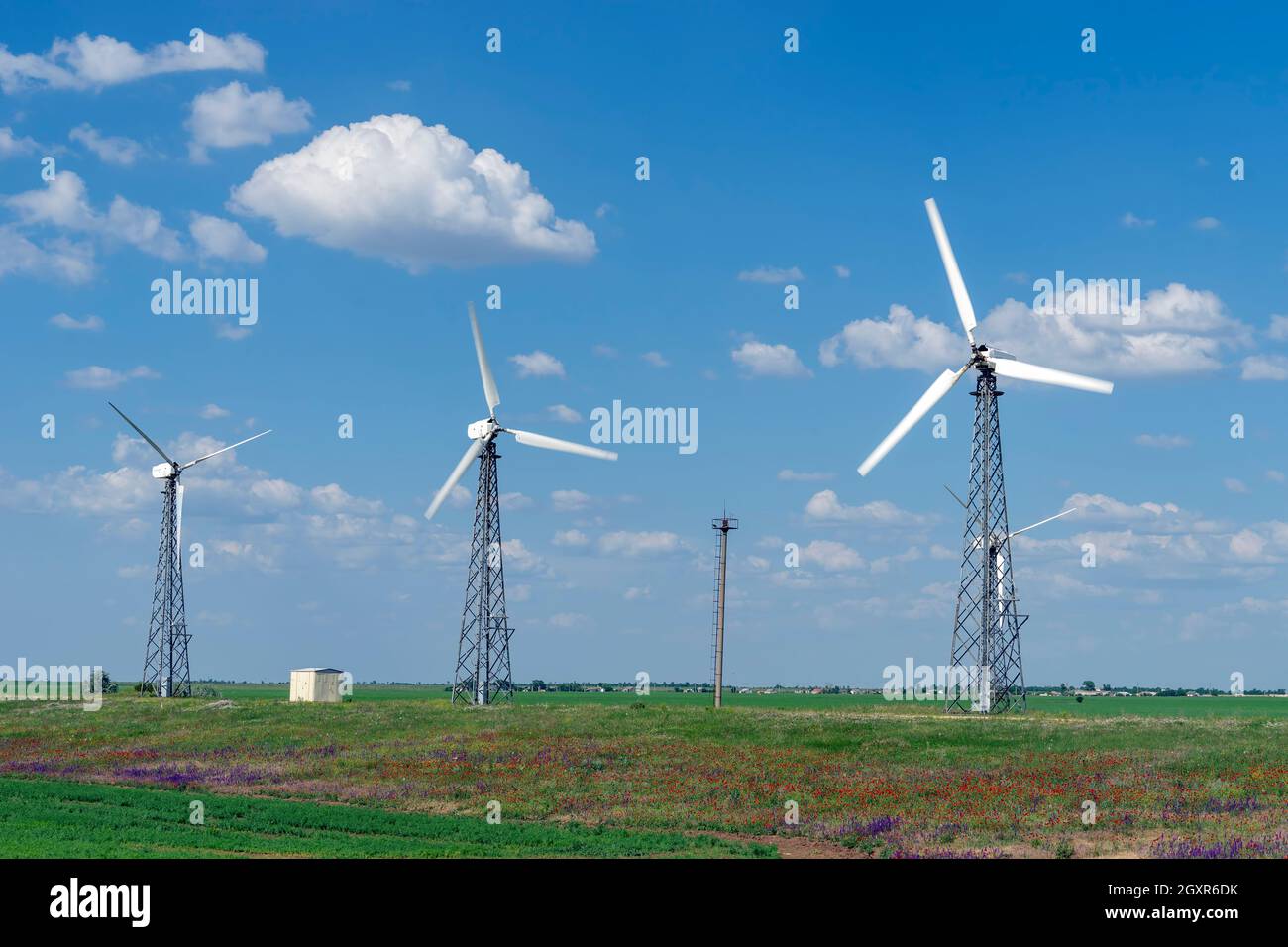Natural landscape with high-voltage tower and wind farm Stock Photo - Alamy