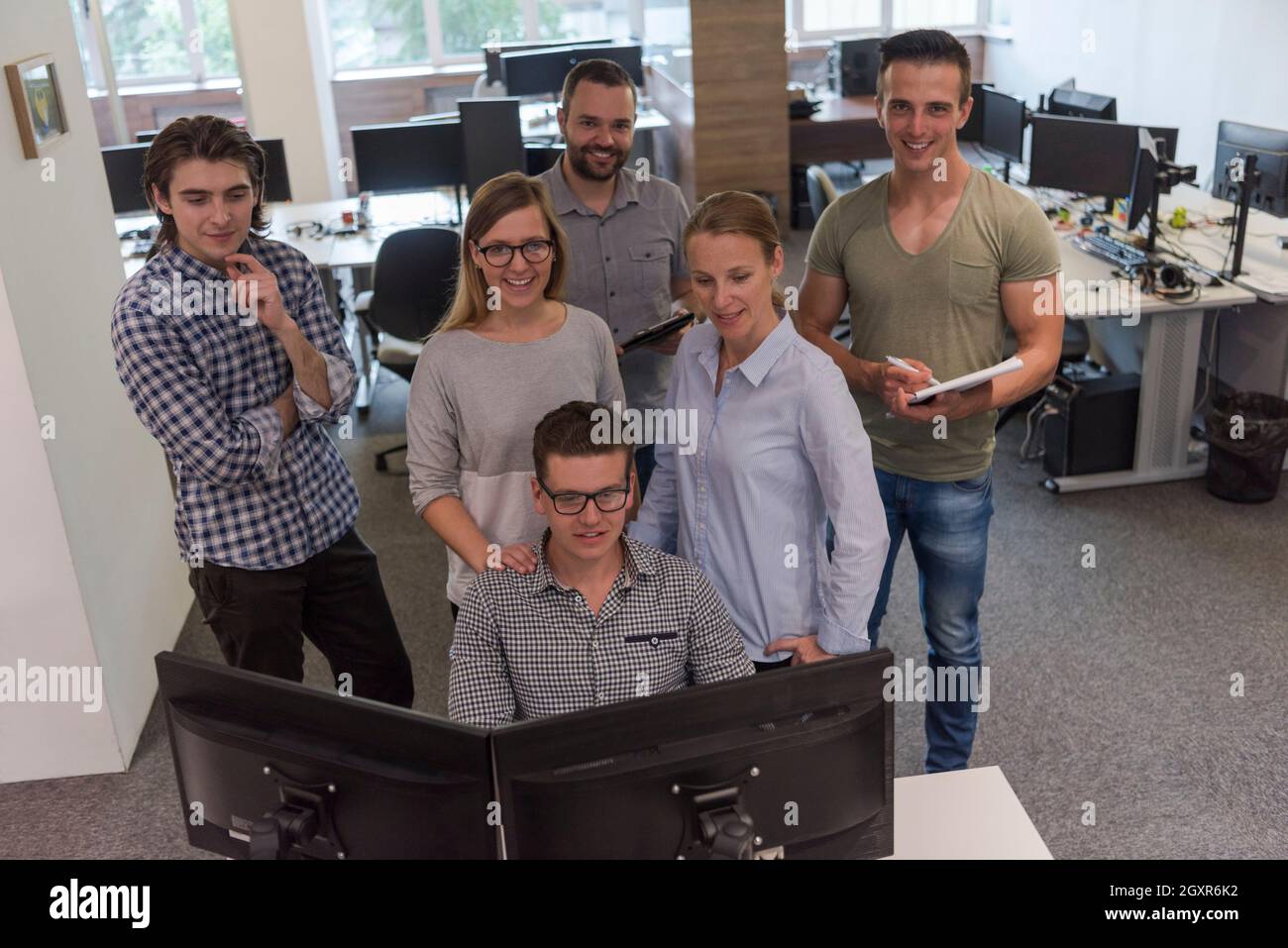 group of young startup business people standing as team at office desk ...