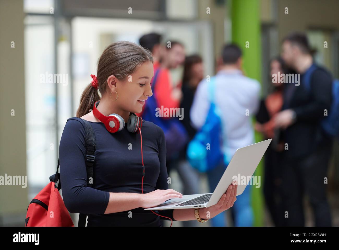 portrait of a happy young student getting ready for class while waiting ...