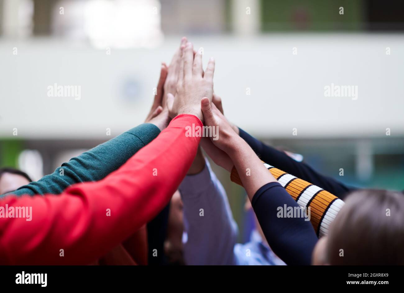 Happy Students Putting their Hands Together in the Air Inside the ...