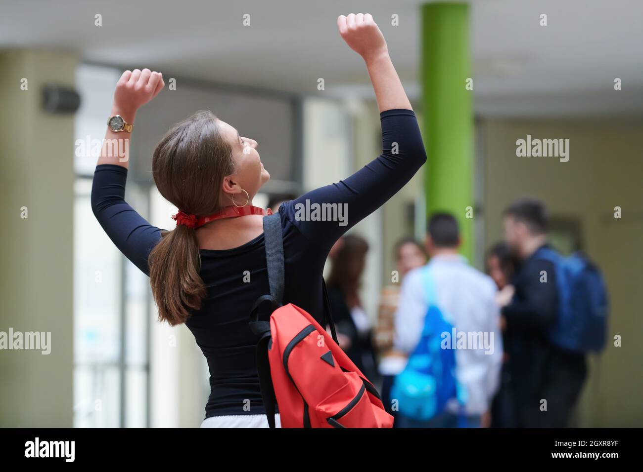 portrait of a happy young student getting ready for class while waiting ...