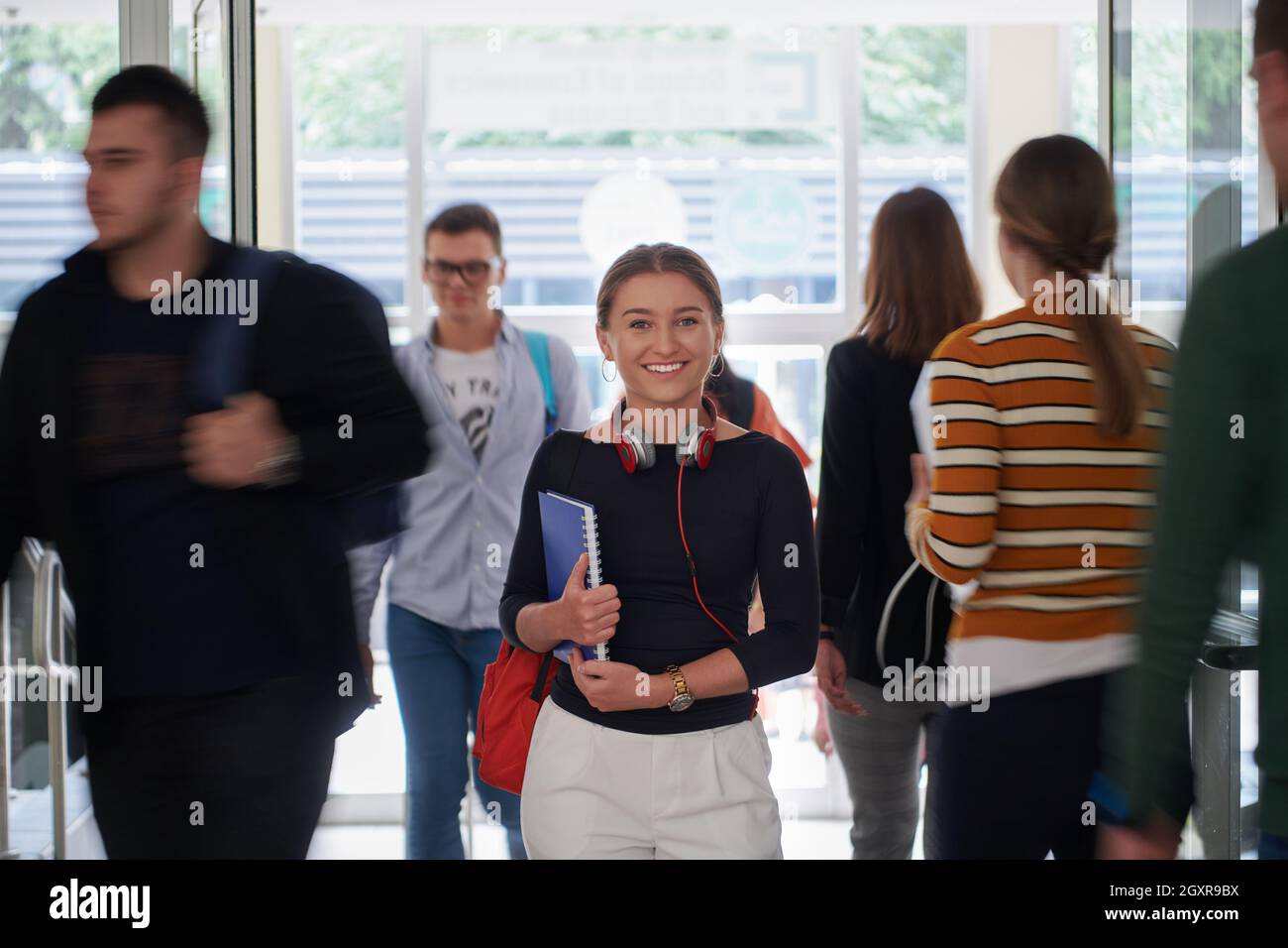 portrait of a happy young student getting ready for class while waiting ...
