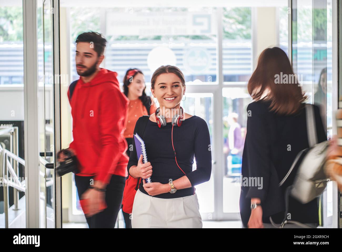 portrait of a happy young student getting ready for class while waiting ...