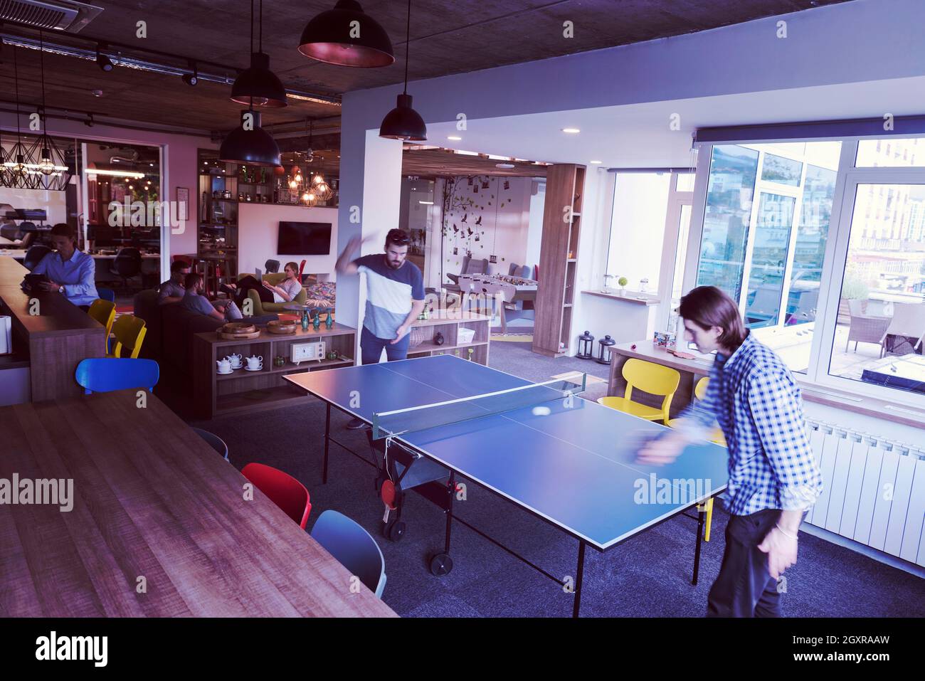 Two young start up business man playing ping pong tennis at modern ...